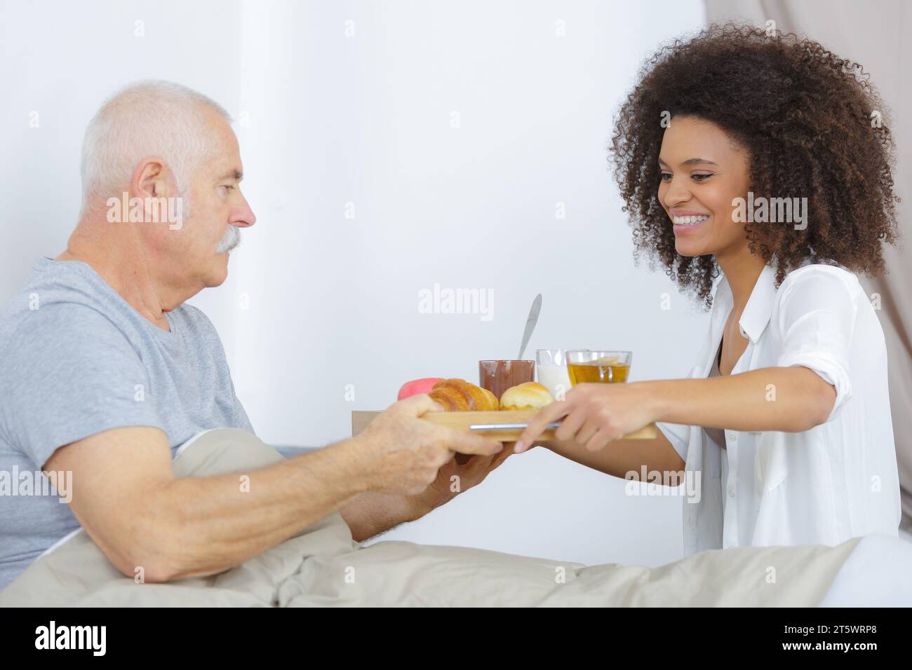 care worker giving lunch to senior Stock Photo - Alamy