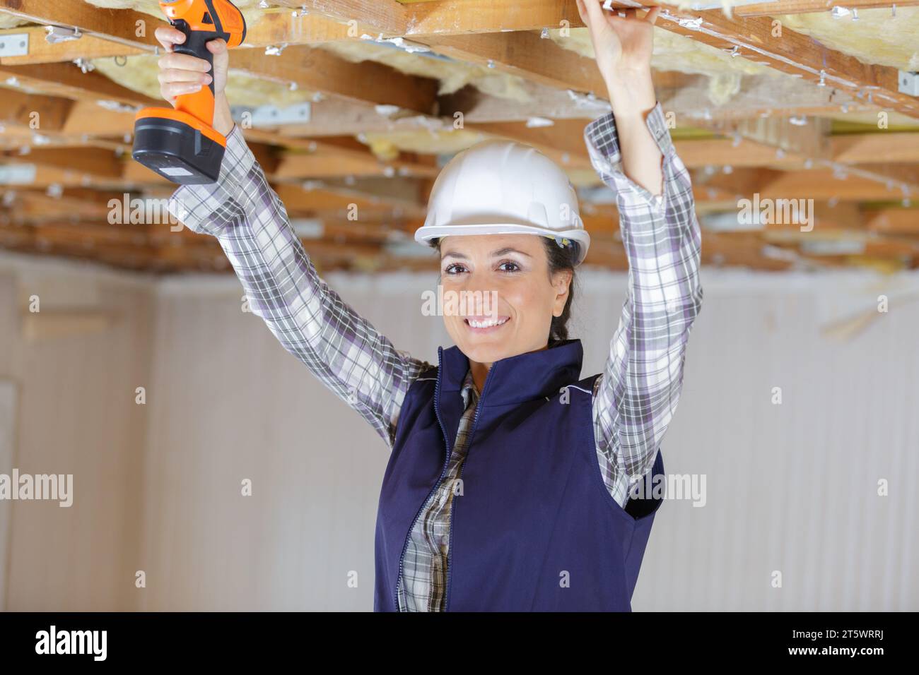 a woman drilling the ceiling Stock Photo - Alamy