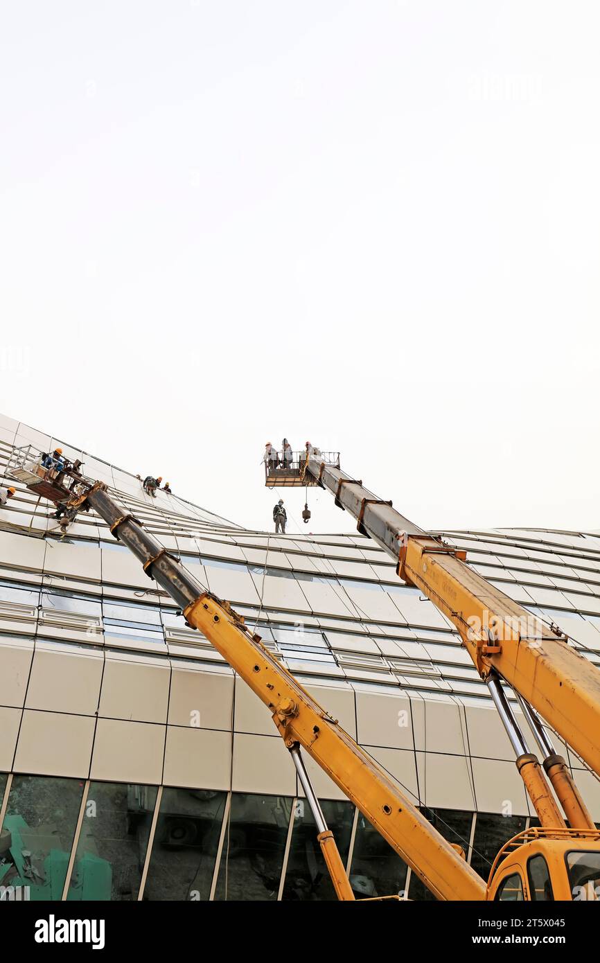crane arm and glass curtain wall in a construction site Stock Photo - Alamy