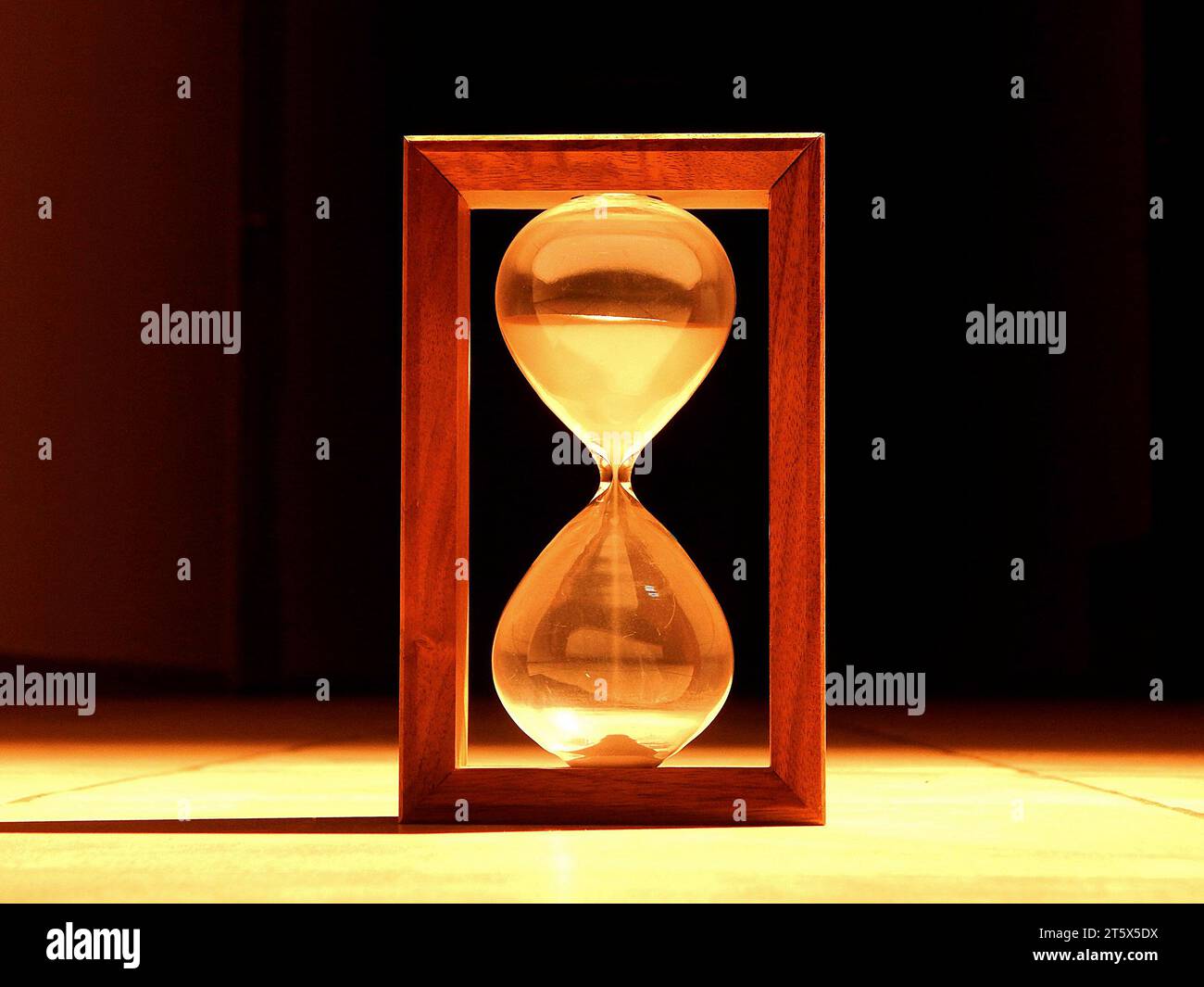 Sandglasses With Falling Sand In Ray Of Light Stock Photo - Alamy