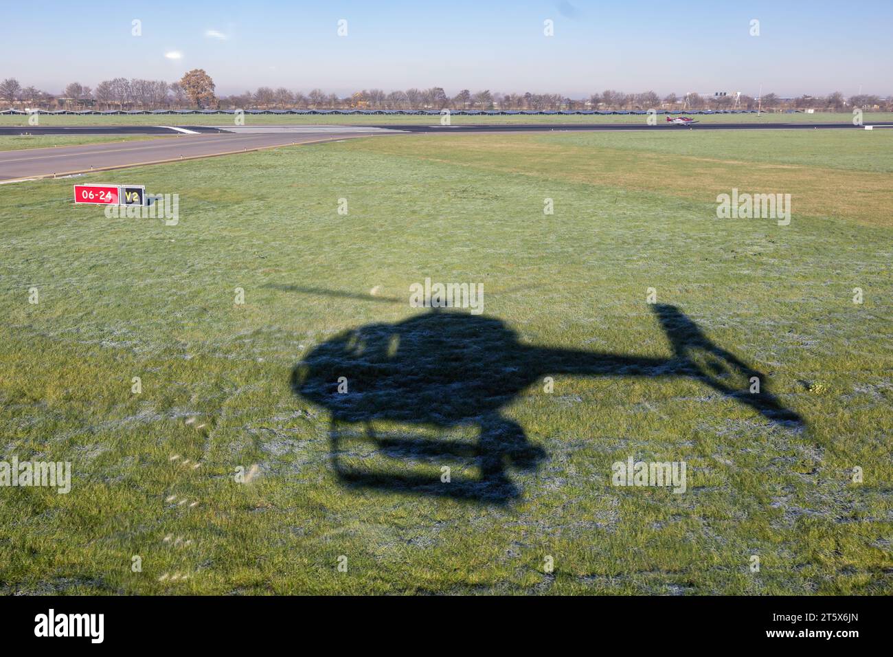Shadow from take-off helicopter at grass near runway Dutch Airport ...