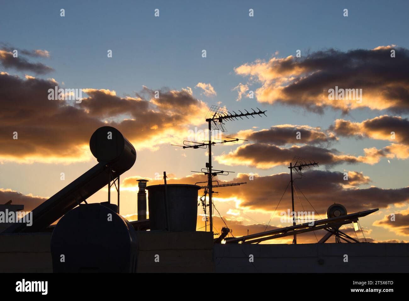 Rooftops silhouetted against a blue cloudy sky at dusk - tv aerials ...