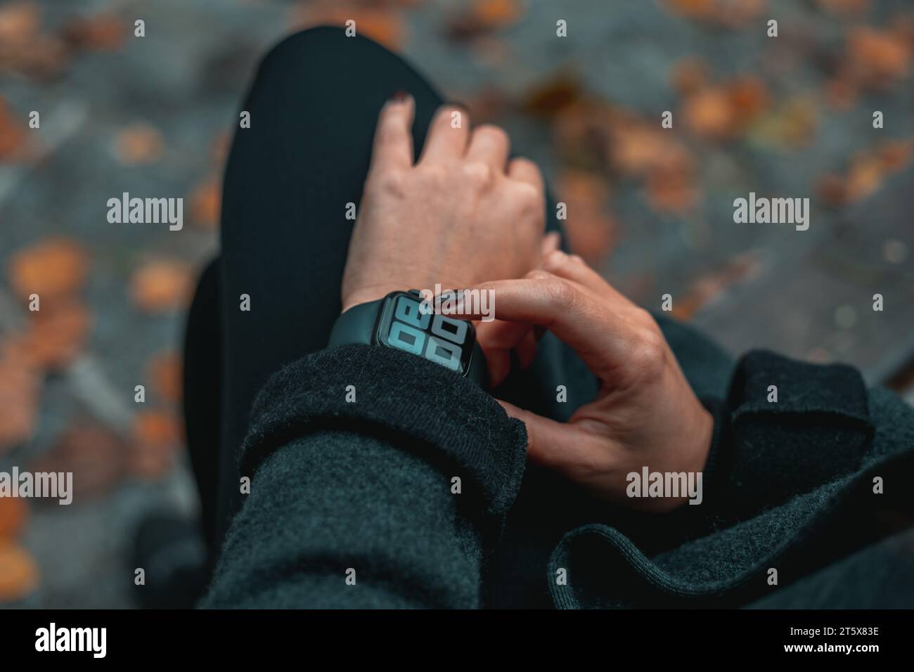 A young woman her coat checks the time on her wristwatch Stock Photo ...