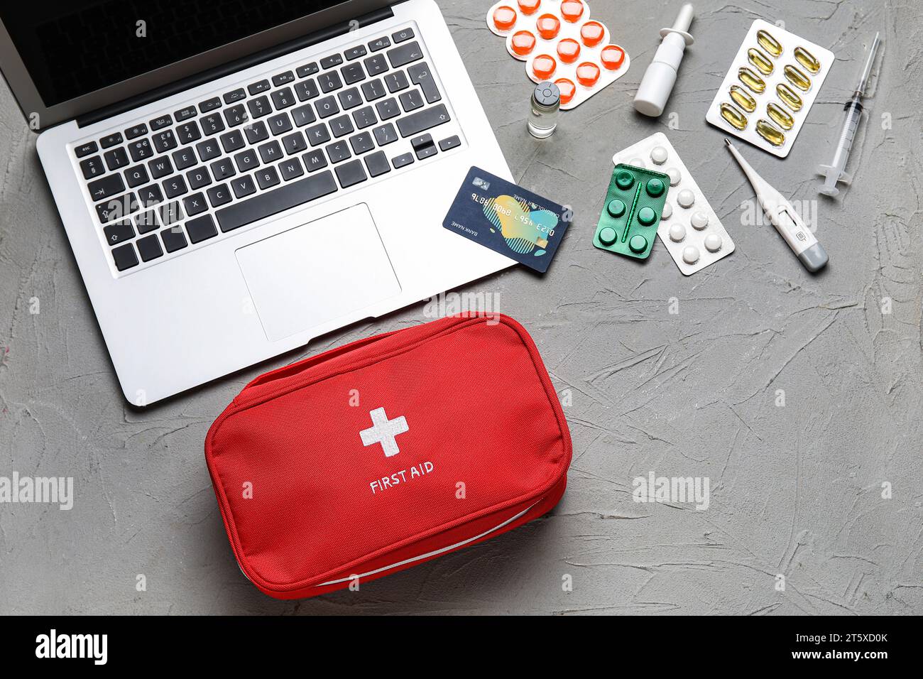 Laptop, credit card and first aid kit on grey background Stock Photo ...