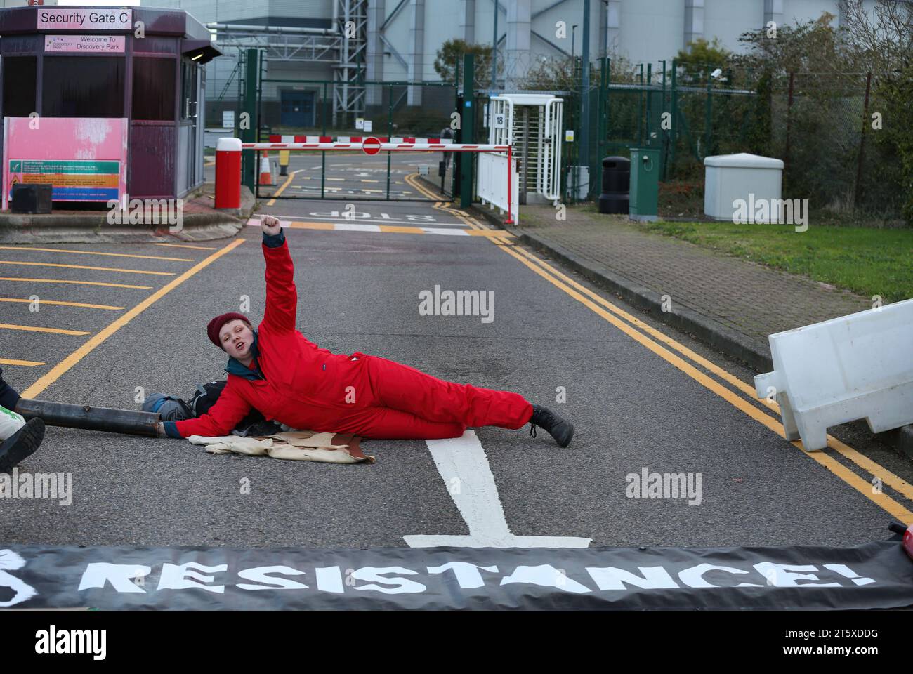 An activist with her arm in a metal lock-on lies across the road to ...