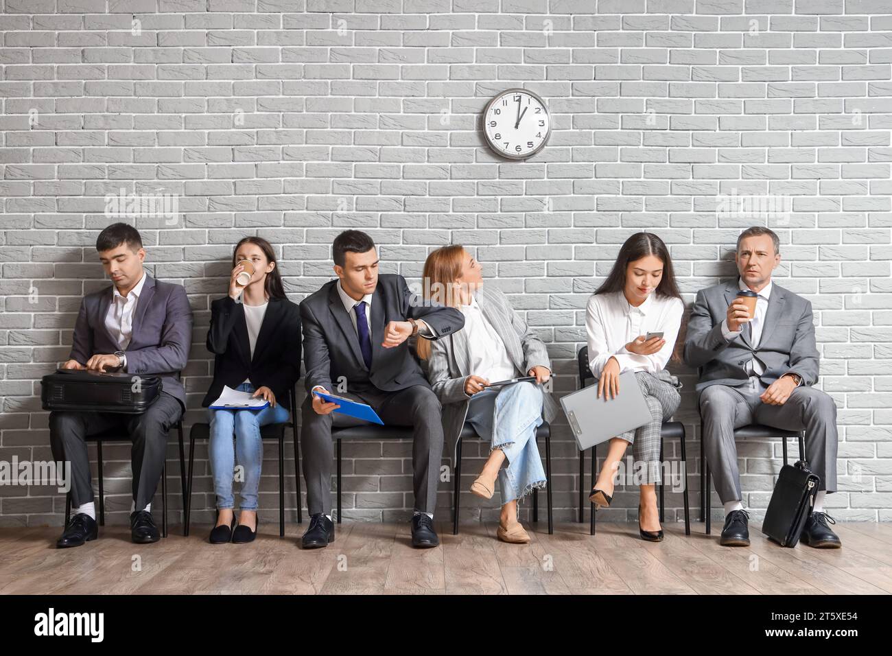 Business people waiting for their turn in office hall Stock Photo - Alamy