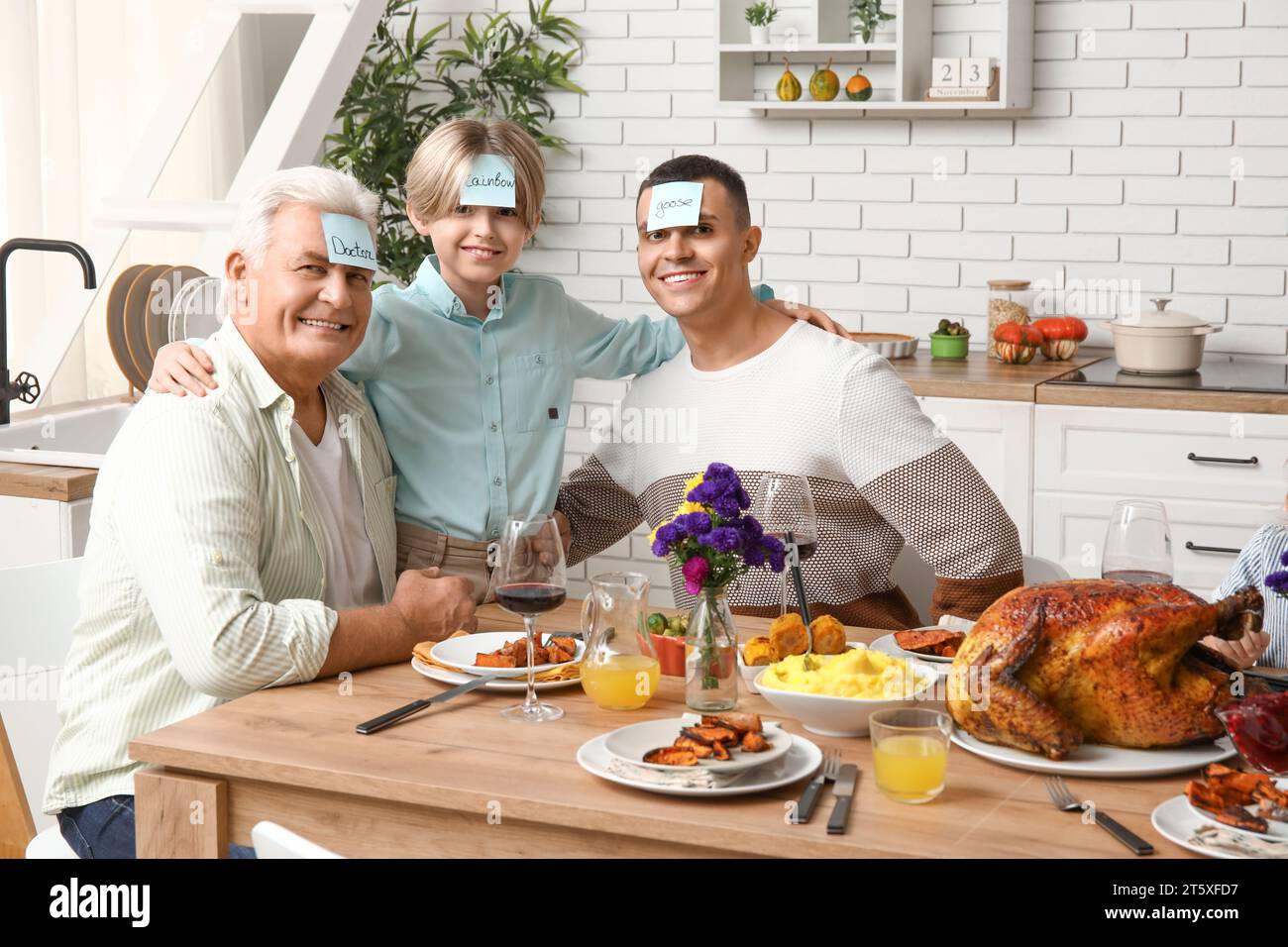 Happy family playing word guessing game at festive table on ...