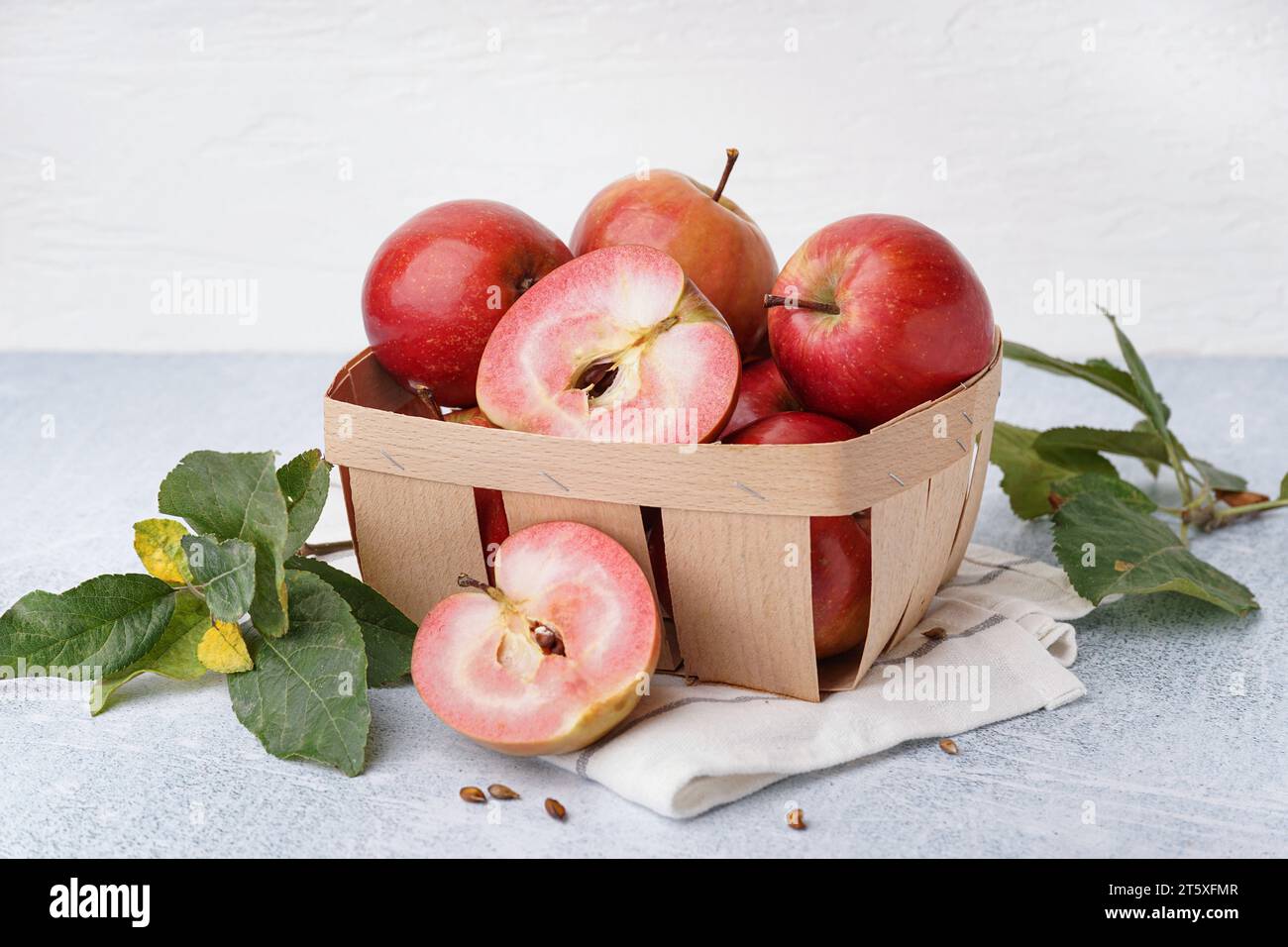 Basket with sweet pink apples and leaves on white background Stock ...