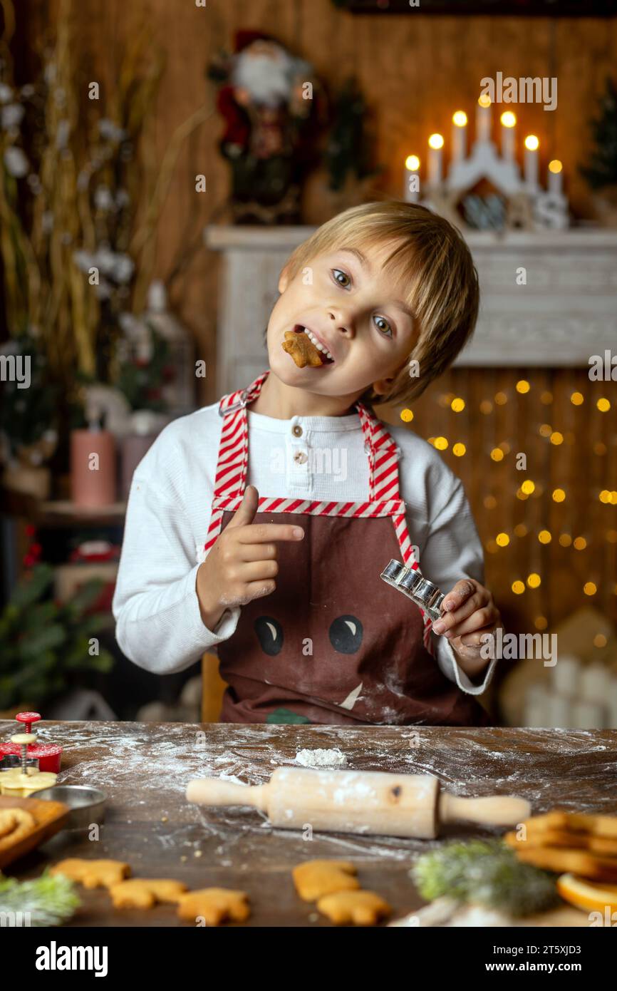 Beautiful blond child, young school boy, writing homework for school in ...