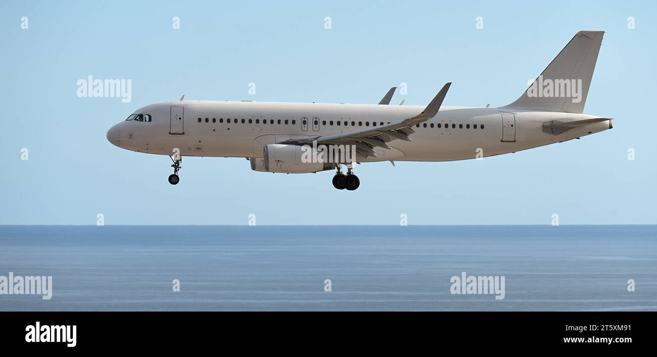 The plane lands over the ocean.Airplane, passengers flying in the sky ...