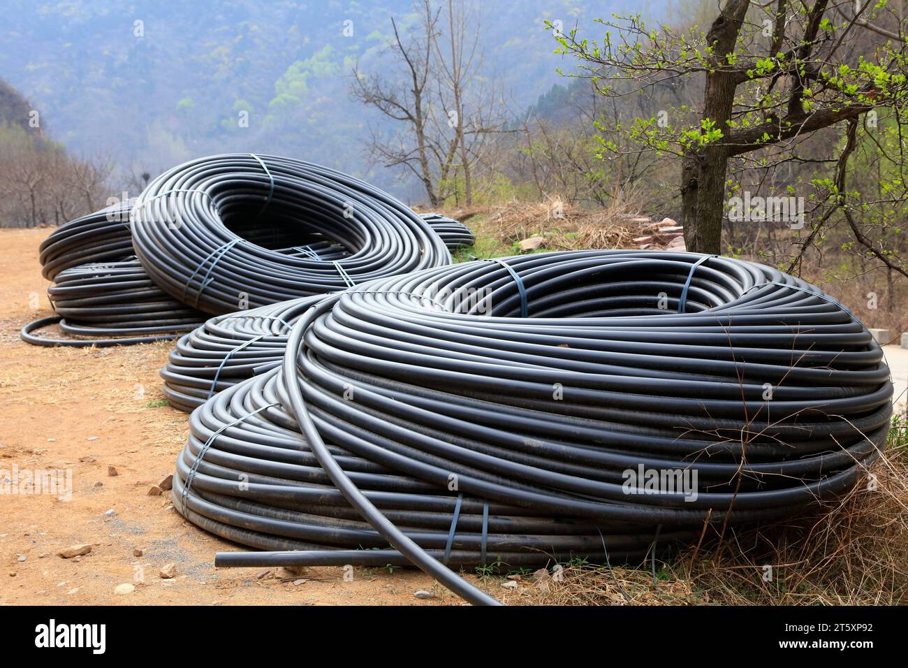 Black plastic pipe curled up together Stock Photo - Alamy