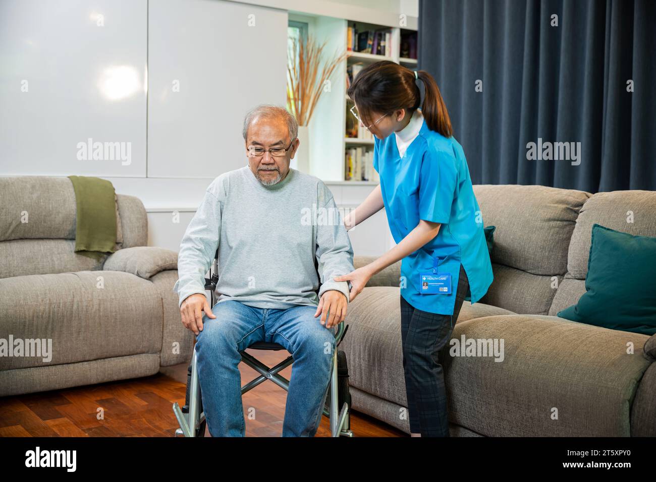 Asian nurse assisting helping senior man patient get up from wheelchair ...