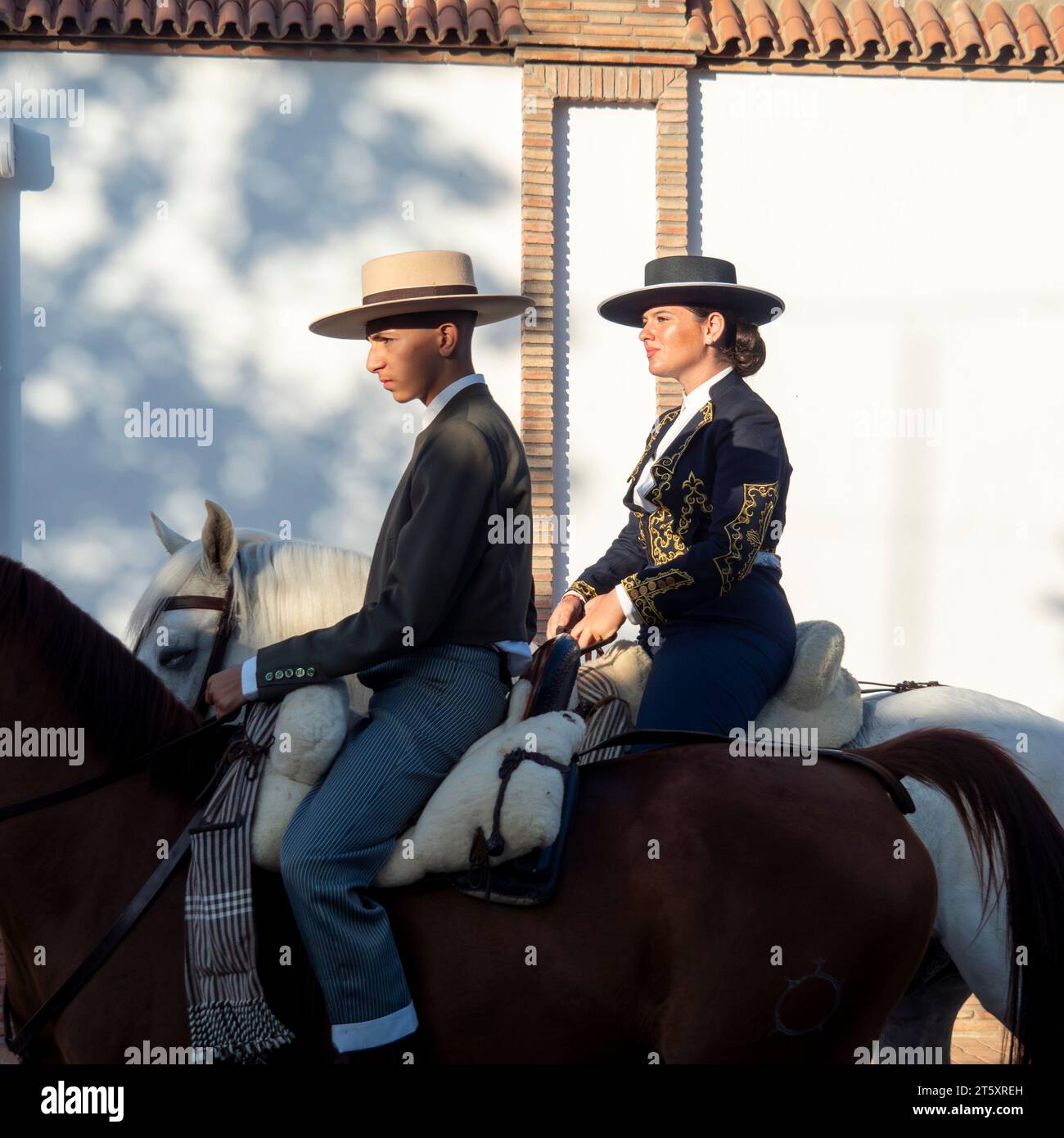 Groups of horse riders dressed in typical Andalusian costume, riding ...