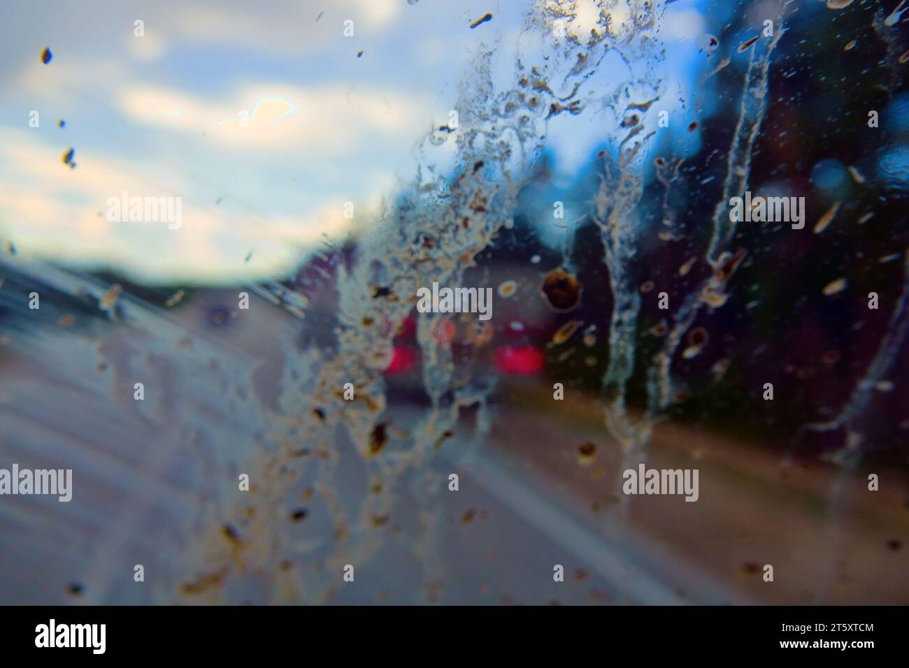 Dirty road after rain. Dirt highway with dirt flies on the windshield ...