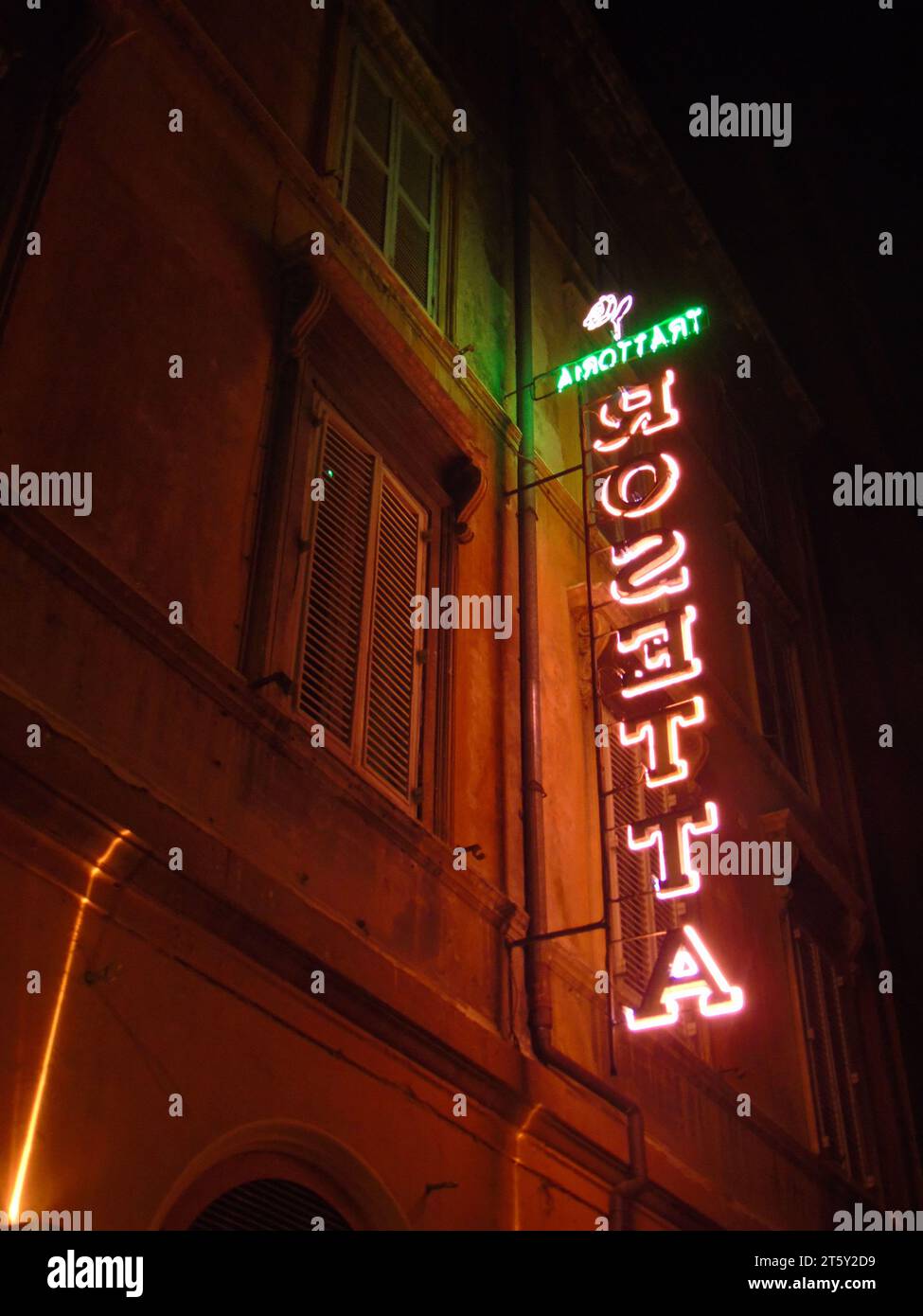 Green and Red neon signage glowing next to some shutters above ...
