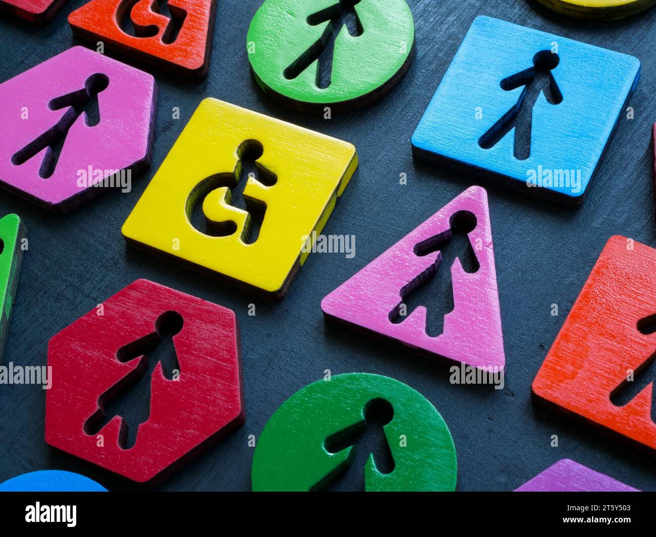 Multi-colored figures and disabled person sign Stock Photo - Alamy