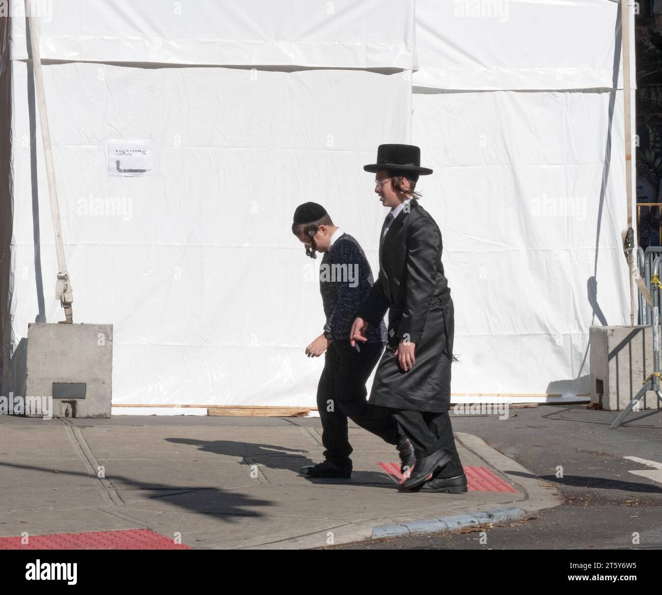 Two young Jewish boys with peyus walk by a Sukkah on Bedford Ave in ...