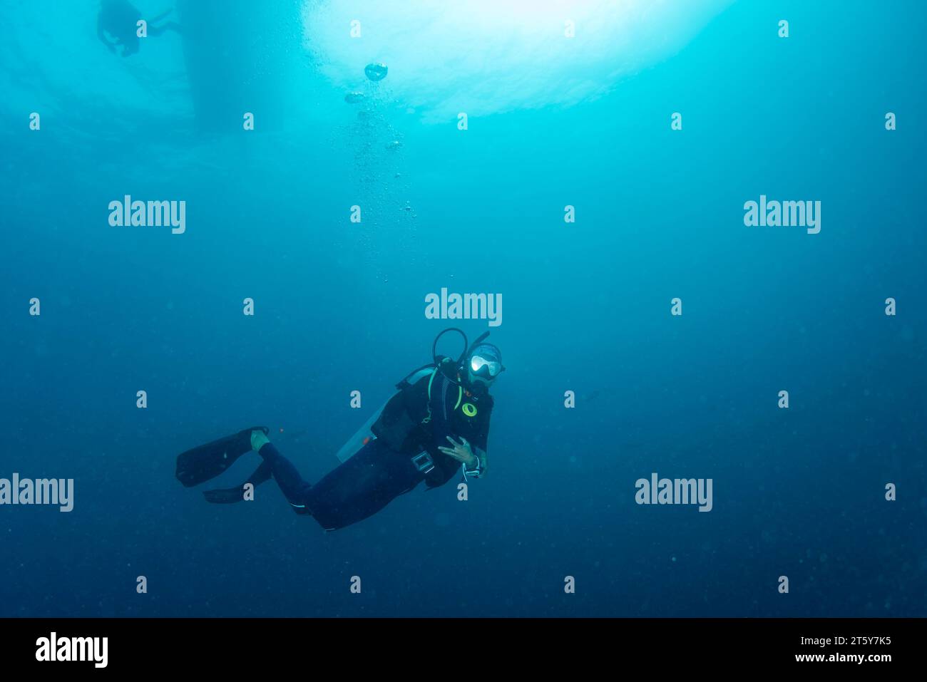 Some scuba divers under the boat in the blue sea Underwater shot with ...