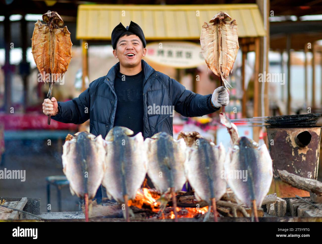 (231107) -- URUMQI, Nov. 7, 2023 (Xinhua) -- A vendor promotes grilled ...