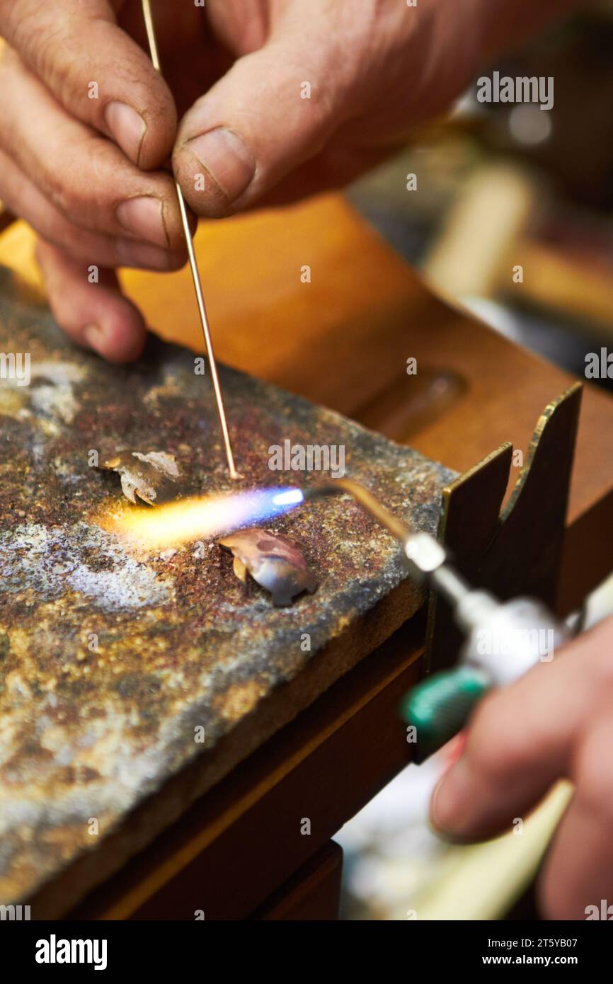 Hands, jewelry and closeup of torch metal for creative art ...