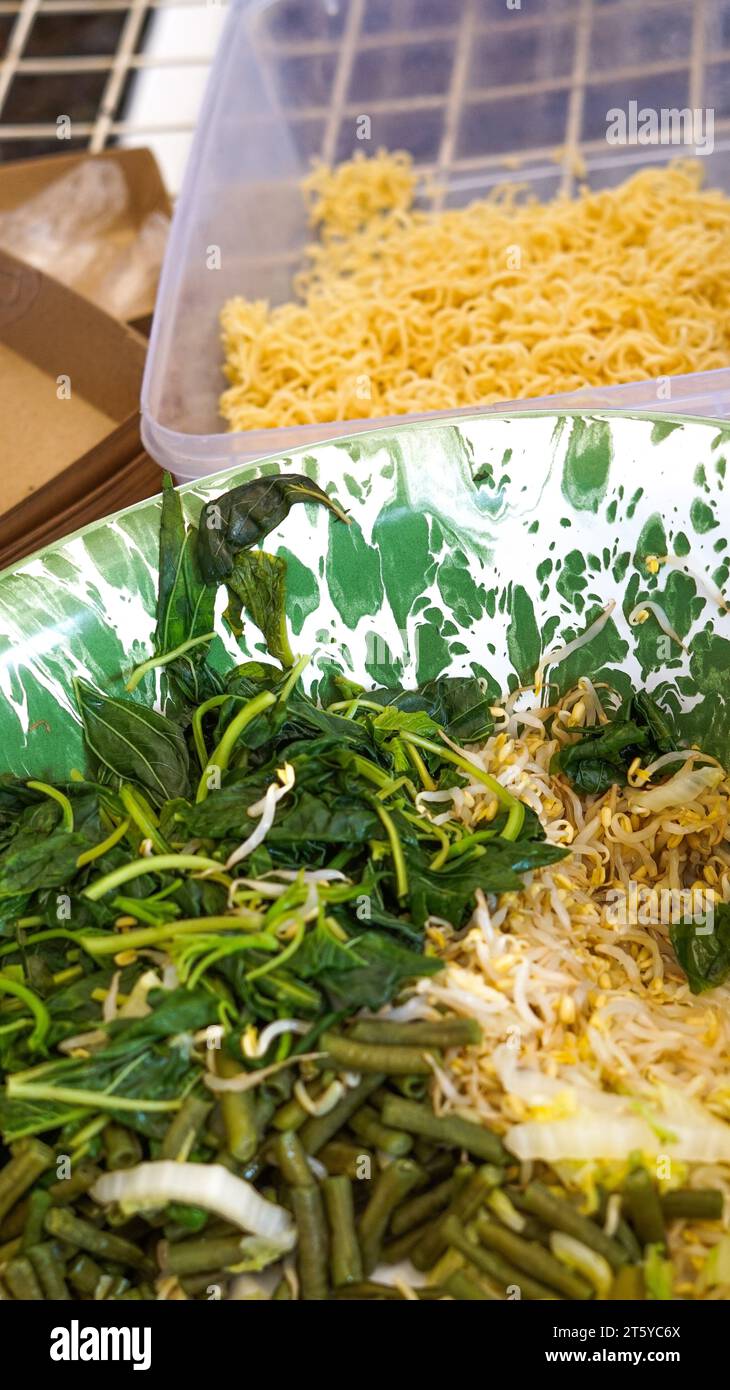 yellow noodles and boiled vegetables such as bean sprouts, spinach ...