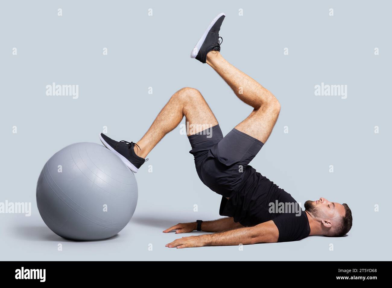 Concentrated muscular young caucasian guy with beard, make exercises ...