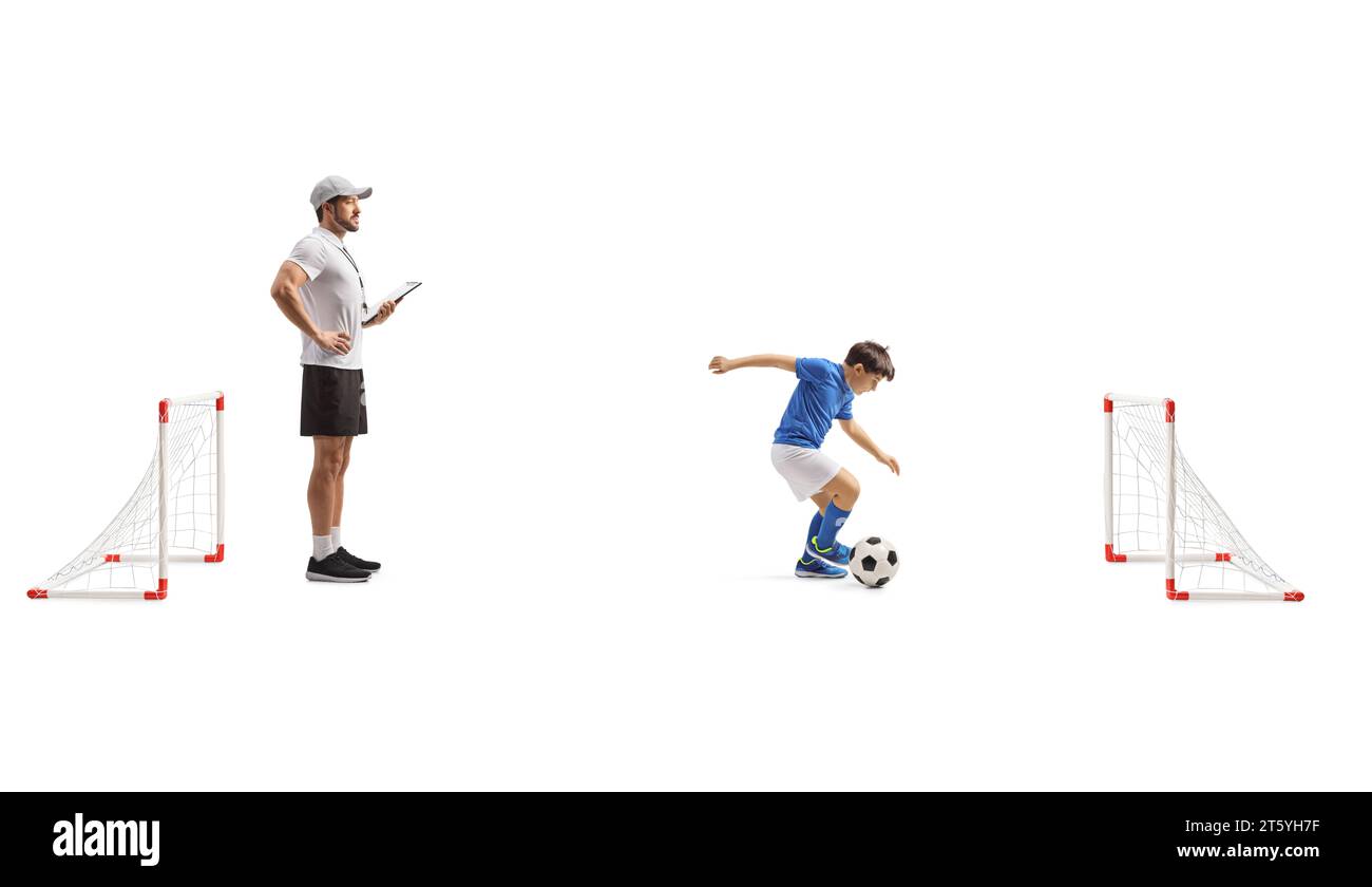 Boy training football with a coach on mini goals isolated on white ...