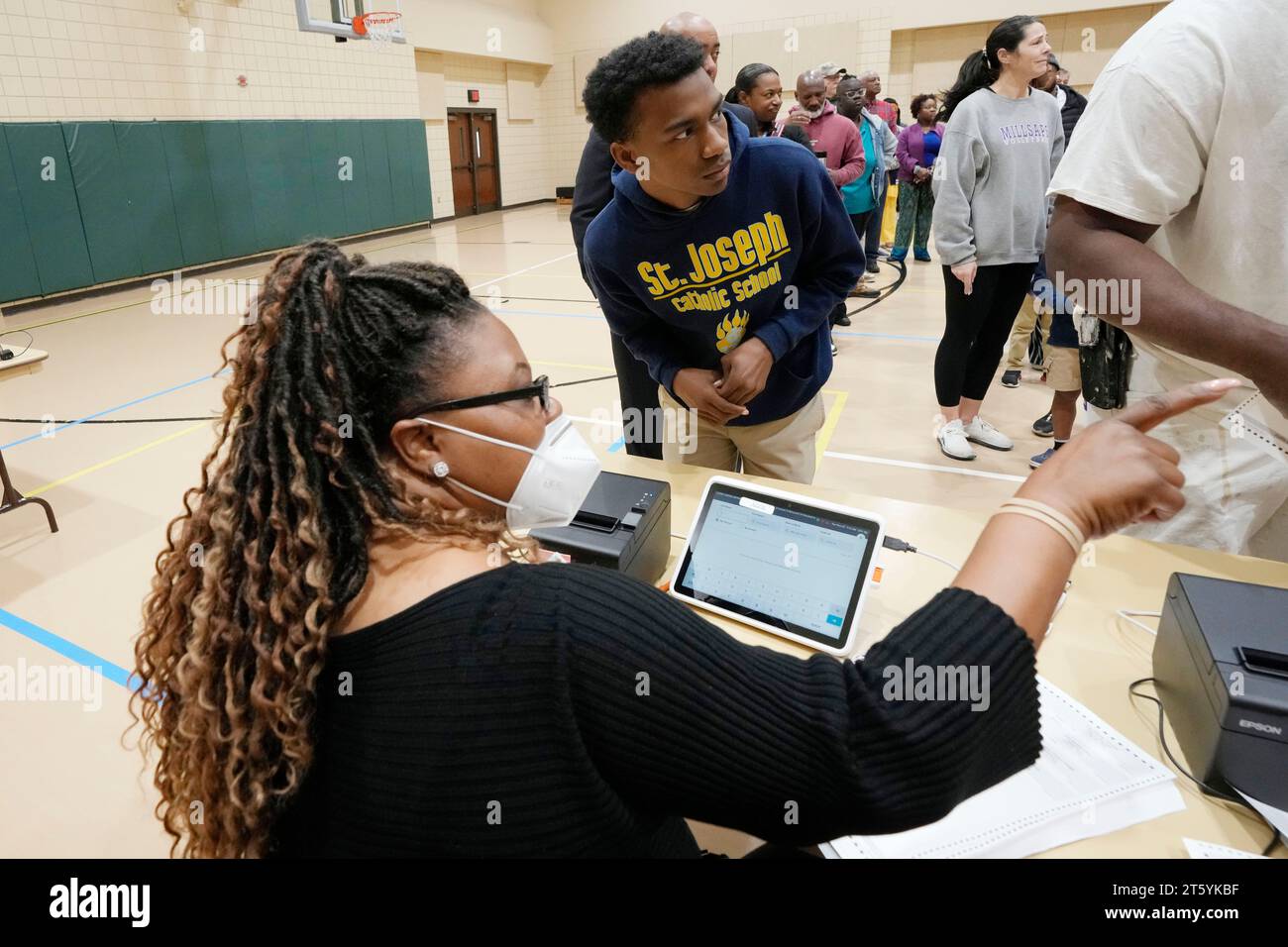 First time voter Jarrett Hall, 18, right, receives direction from ...