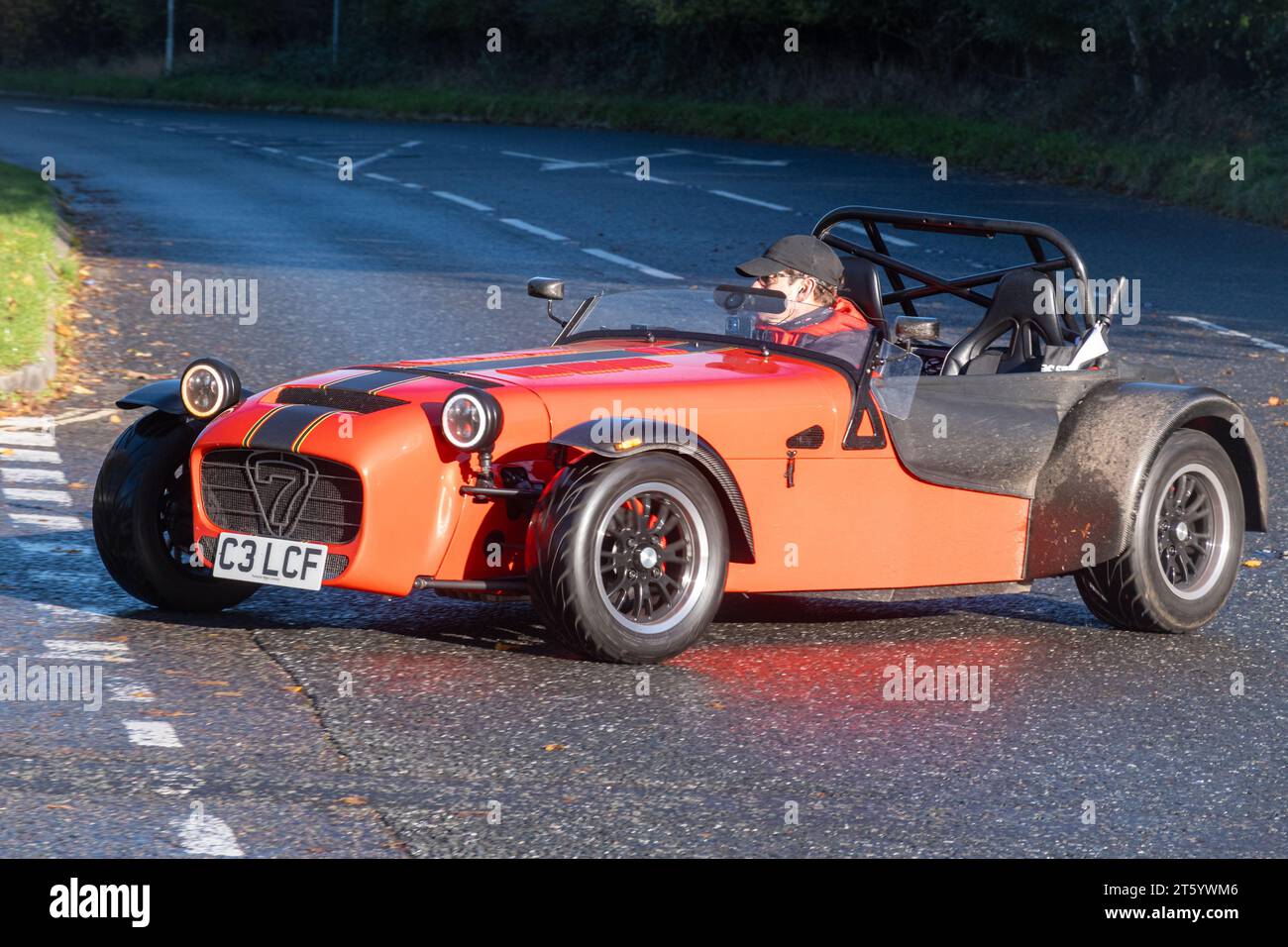 An orange 2013 Caterham Seven sports car on the road, England, UK Stock ...