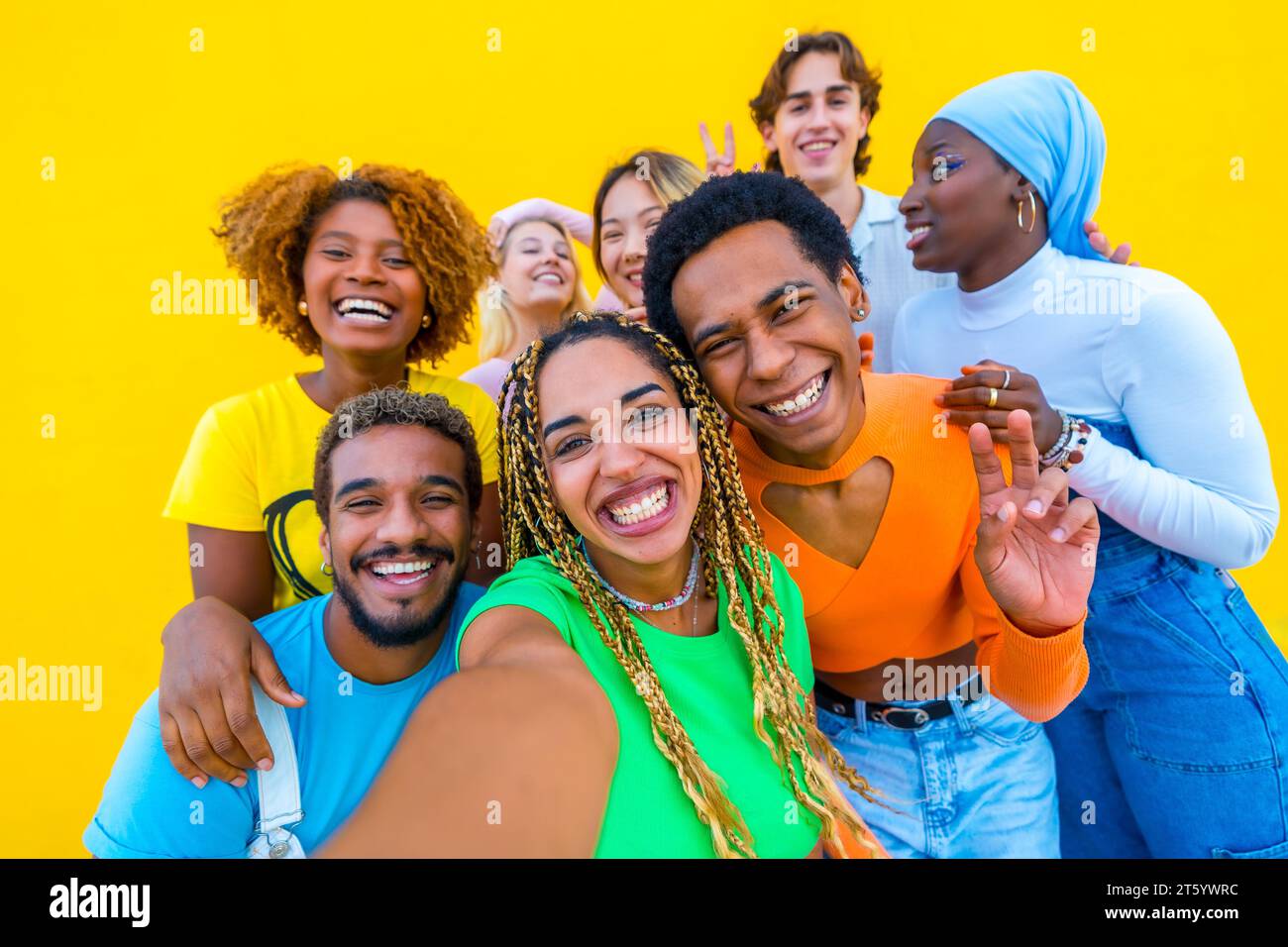 Group of diverse young people smiling while taking a selfie in a yellow ... Group of diverse young people smiling while taking a selfie in a yellow ...