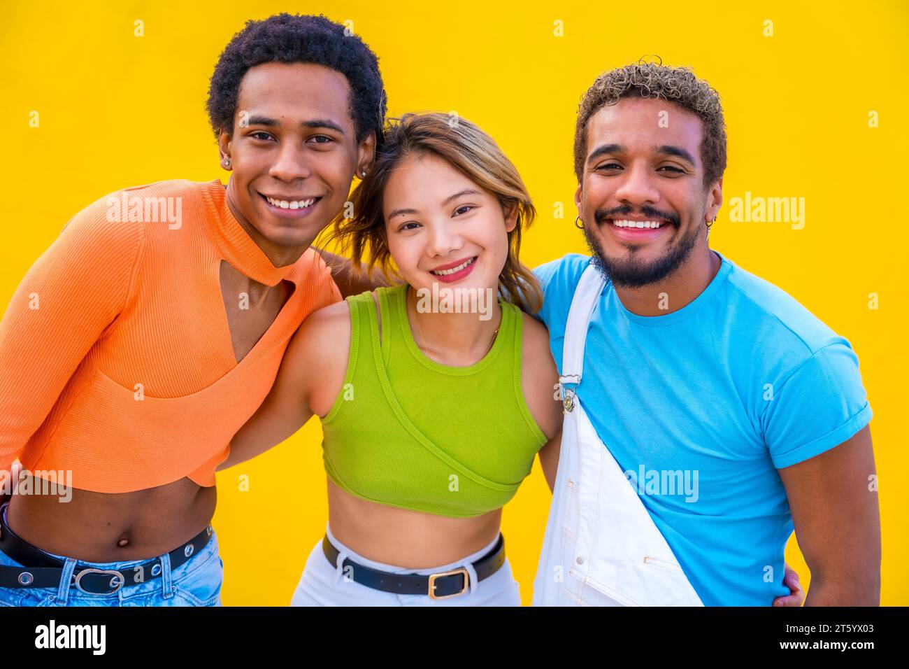 Gender and ethnic diverse people posing smiling at camera in a yellow ...