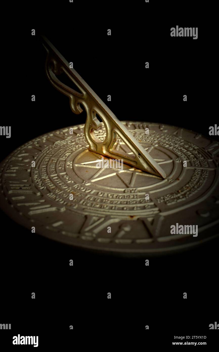 Antique brass sundial with time and calendar engraved on the surface ...