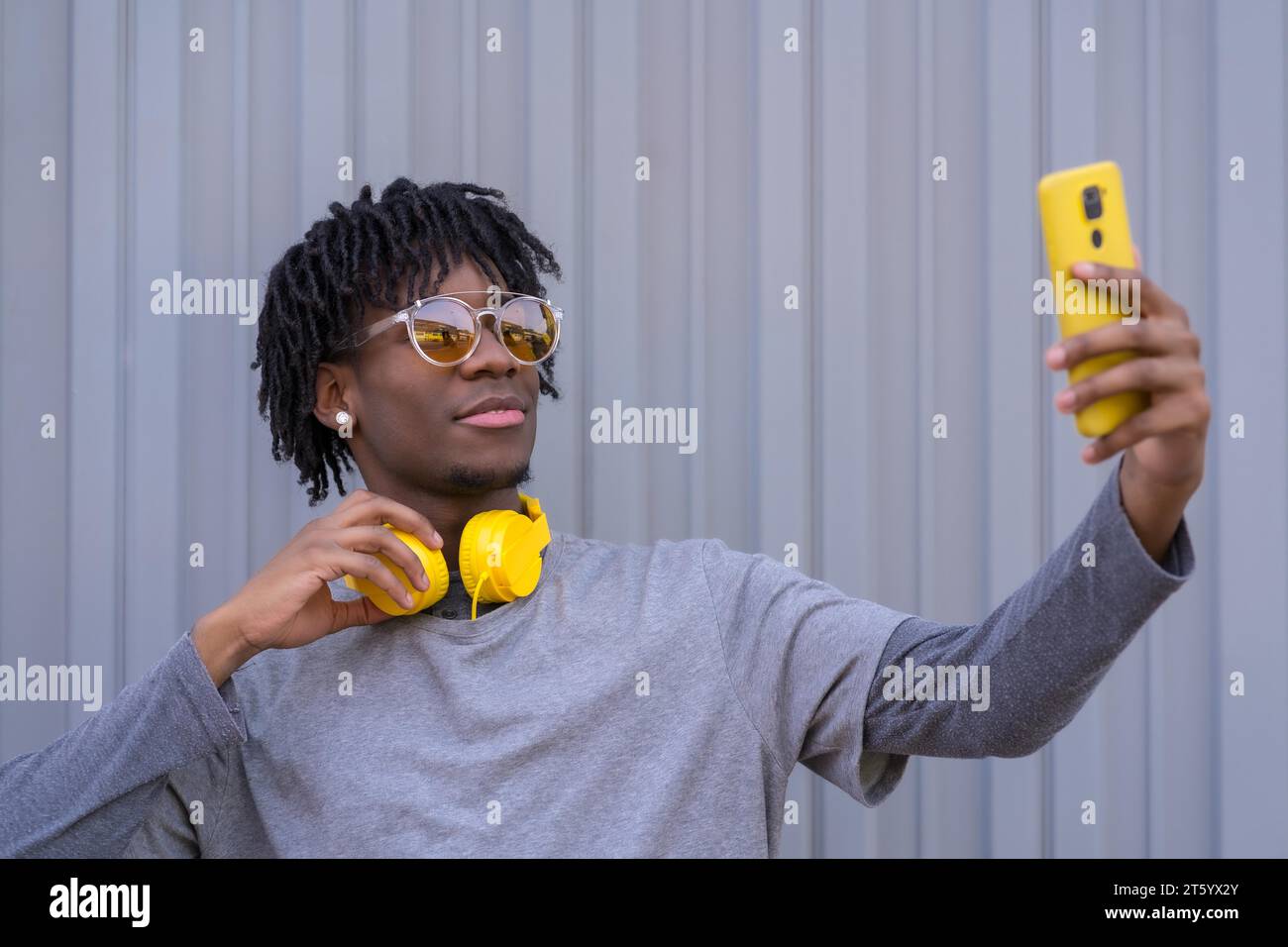 African cool man taking a selfie next to a urban grey wall Stock Photo ...
