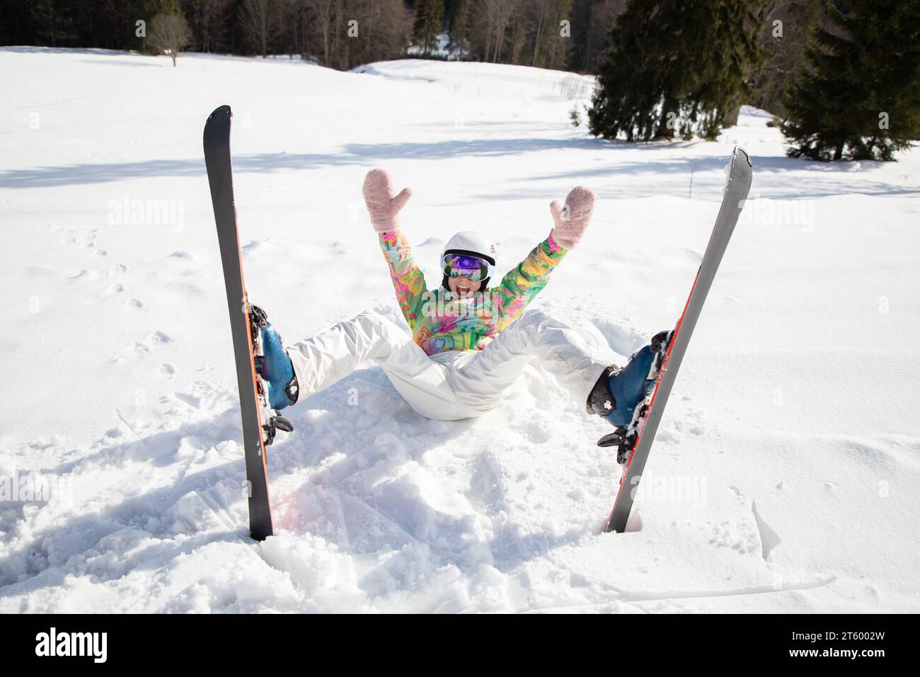 young woman or teenage girl in good mood while skiing fell and lies ...