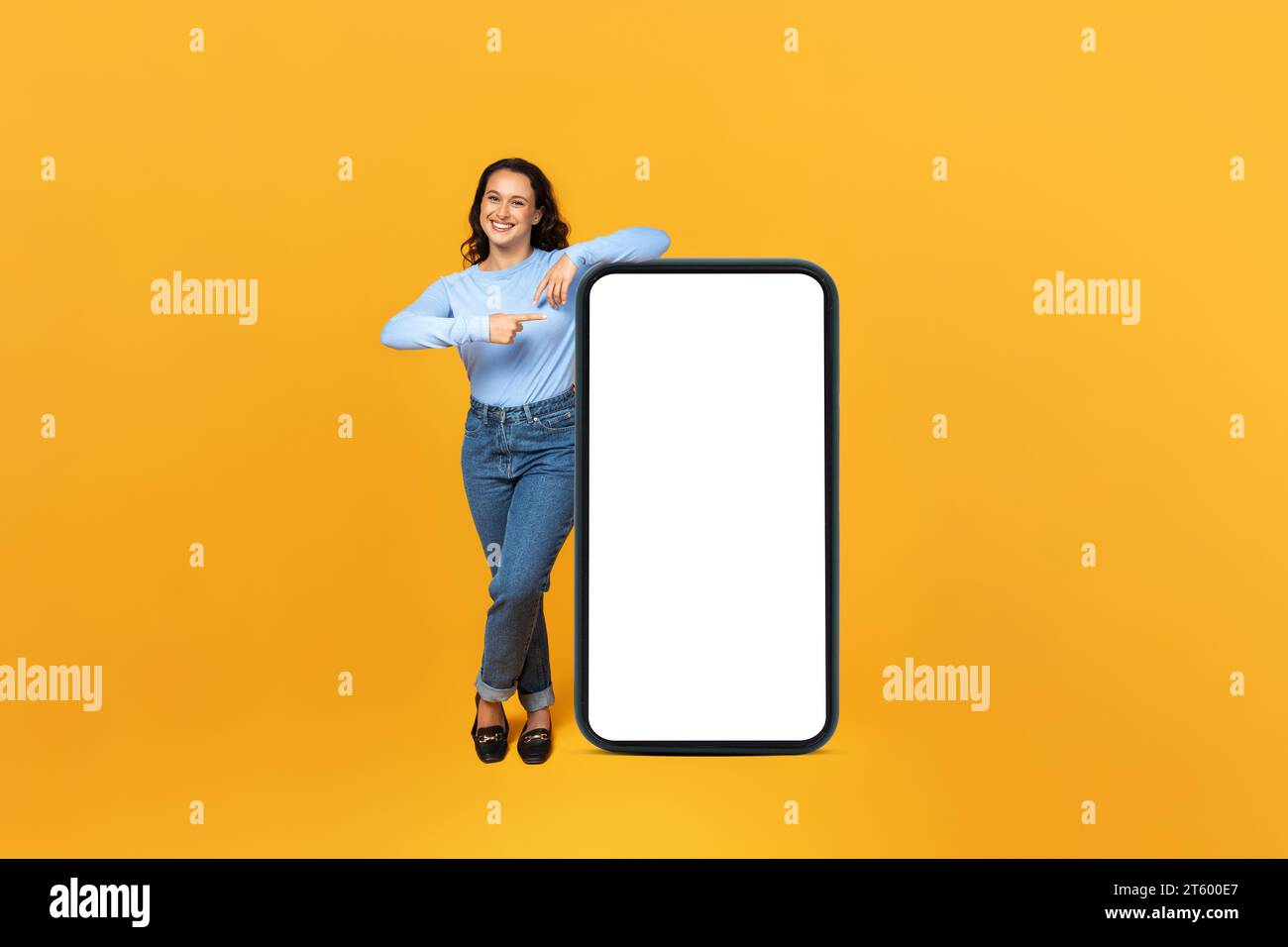 Cheerful millennial lady showing huge phone with blank screen Stock ...
