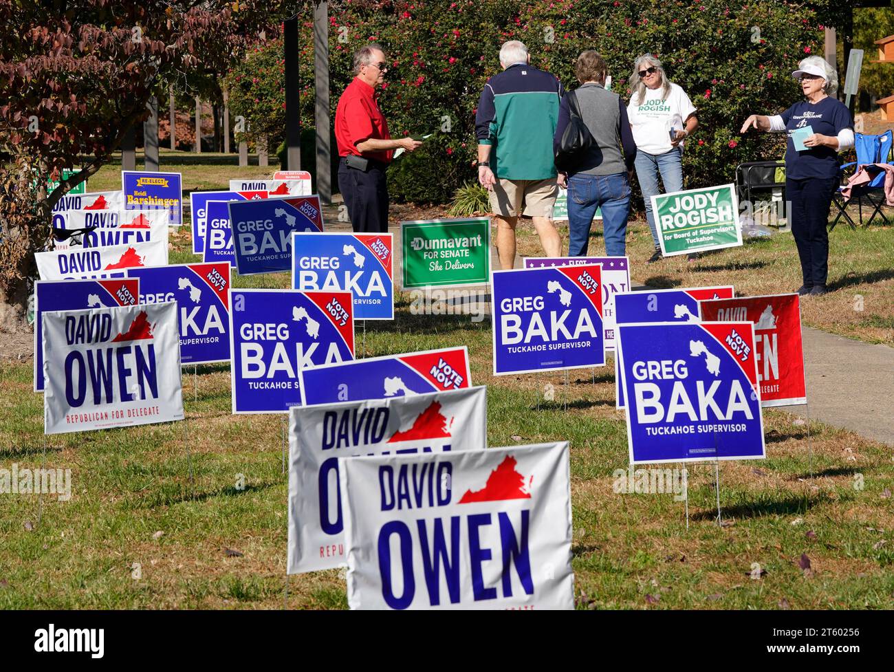 Volunteers hand out sample ballots as voters walk to a polling station ...