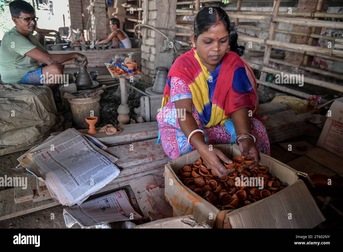 A worker is sorting earthen lamp in the pottery village named ...
