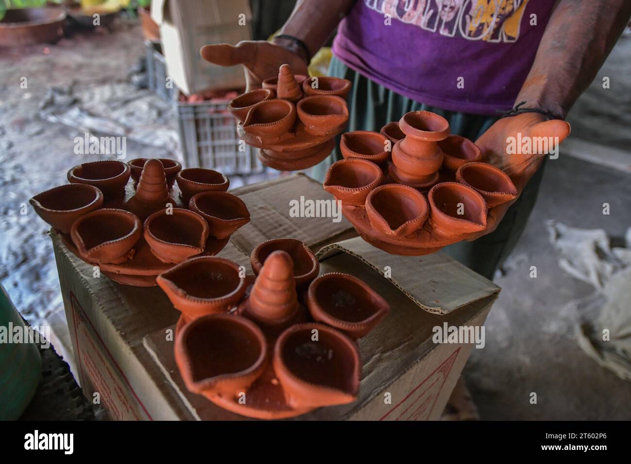 A worker is sorting earthen lamp in the pottery village named ...