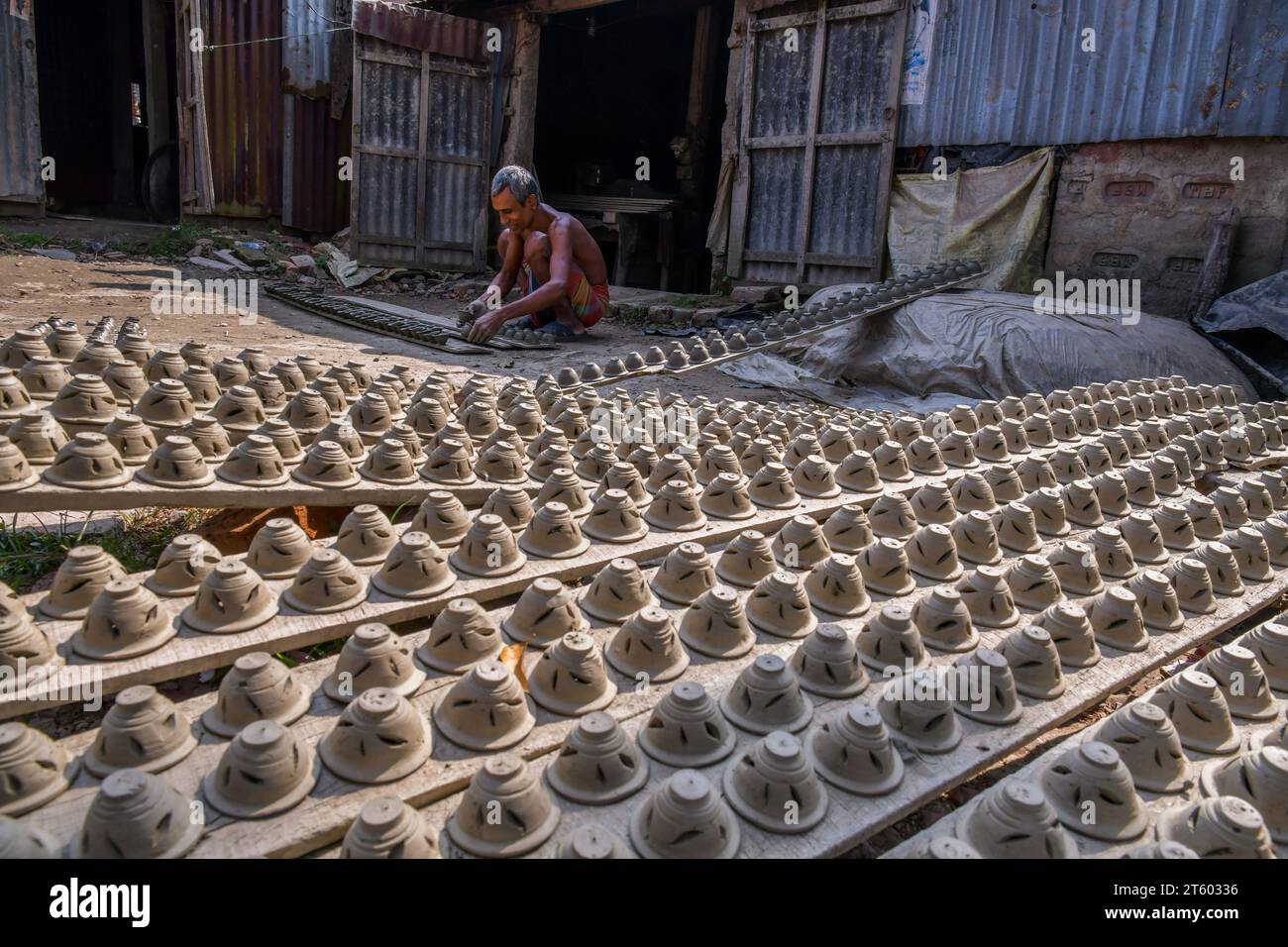 A worker is sorting earthen lamp in the pottery village named ...