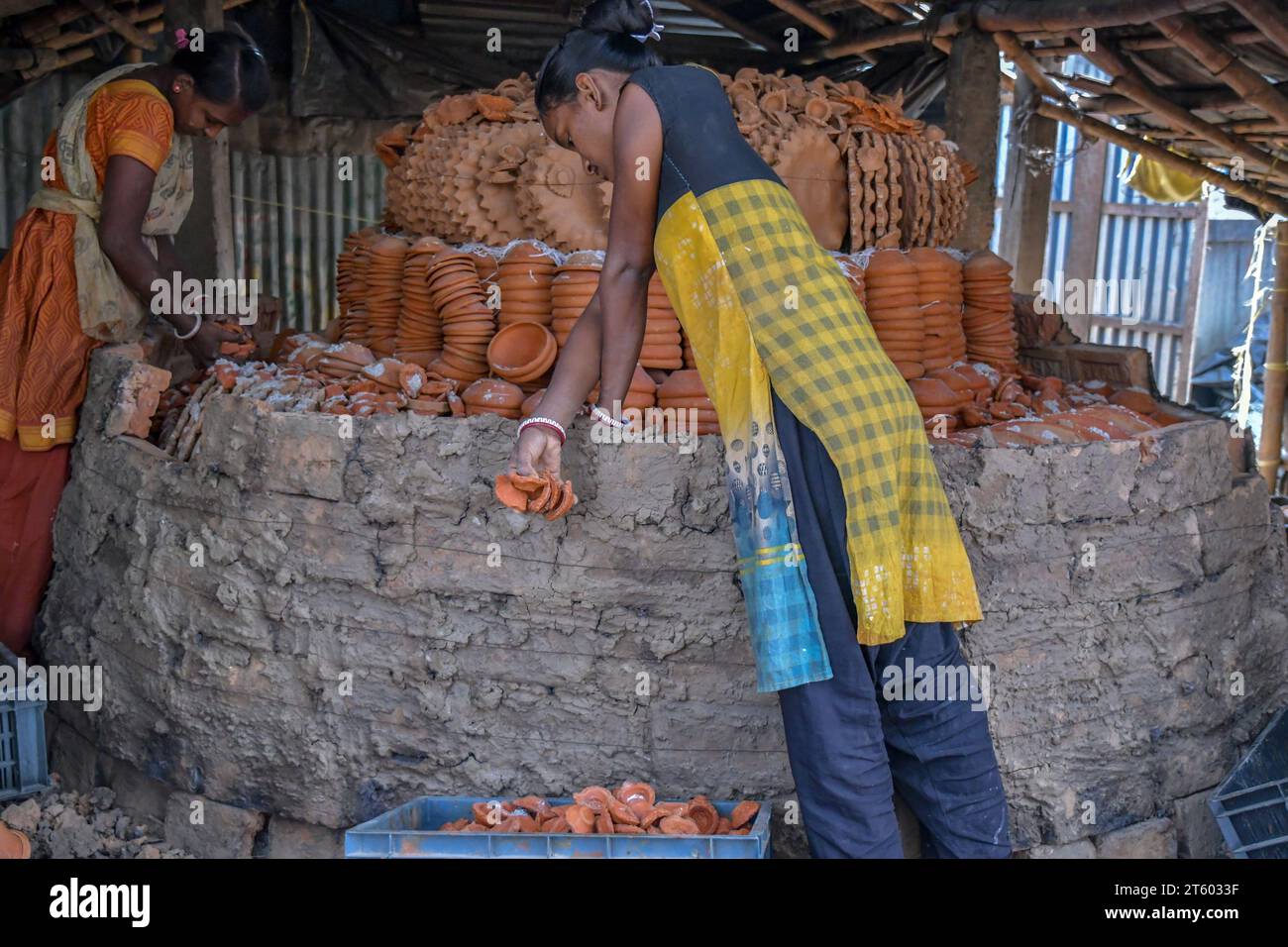 Female workers are sorting earthen lamps in the pottery village named ...