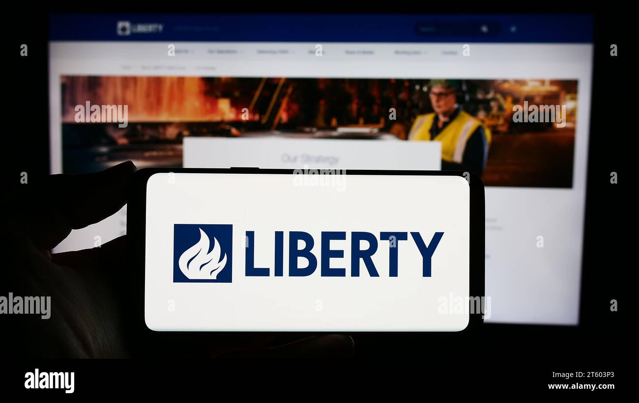 Person holding smartphone with logo of British metals company Liberty ...