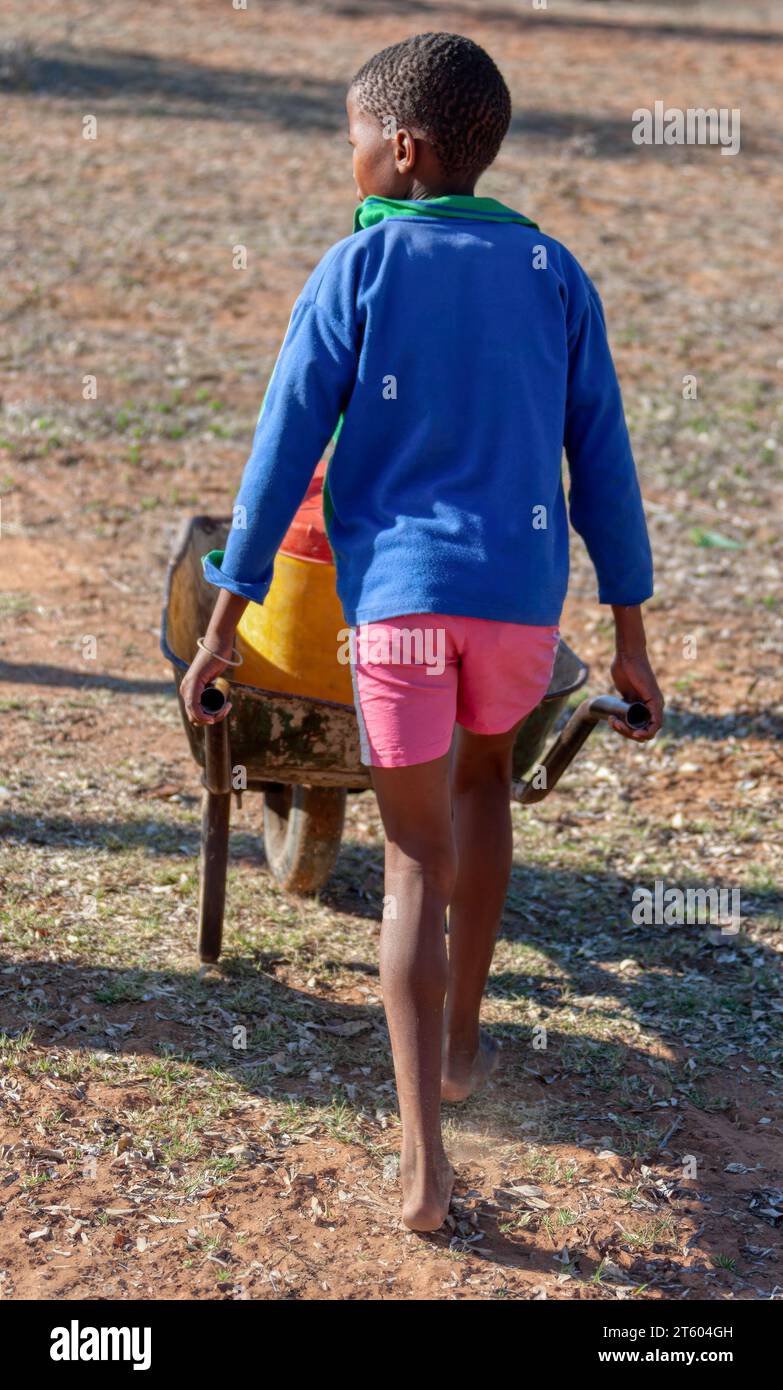 African child with a wheelbarrow carry water , shortage during a long ...