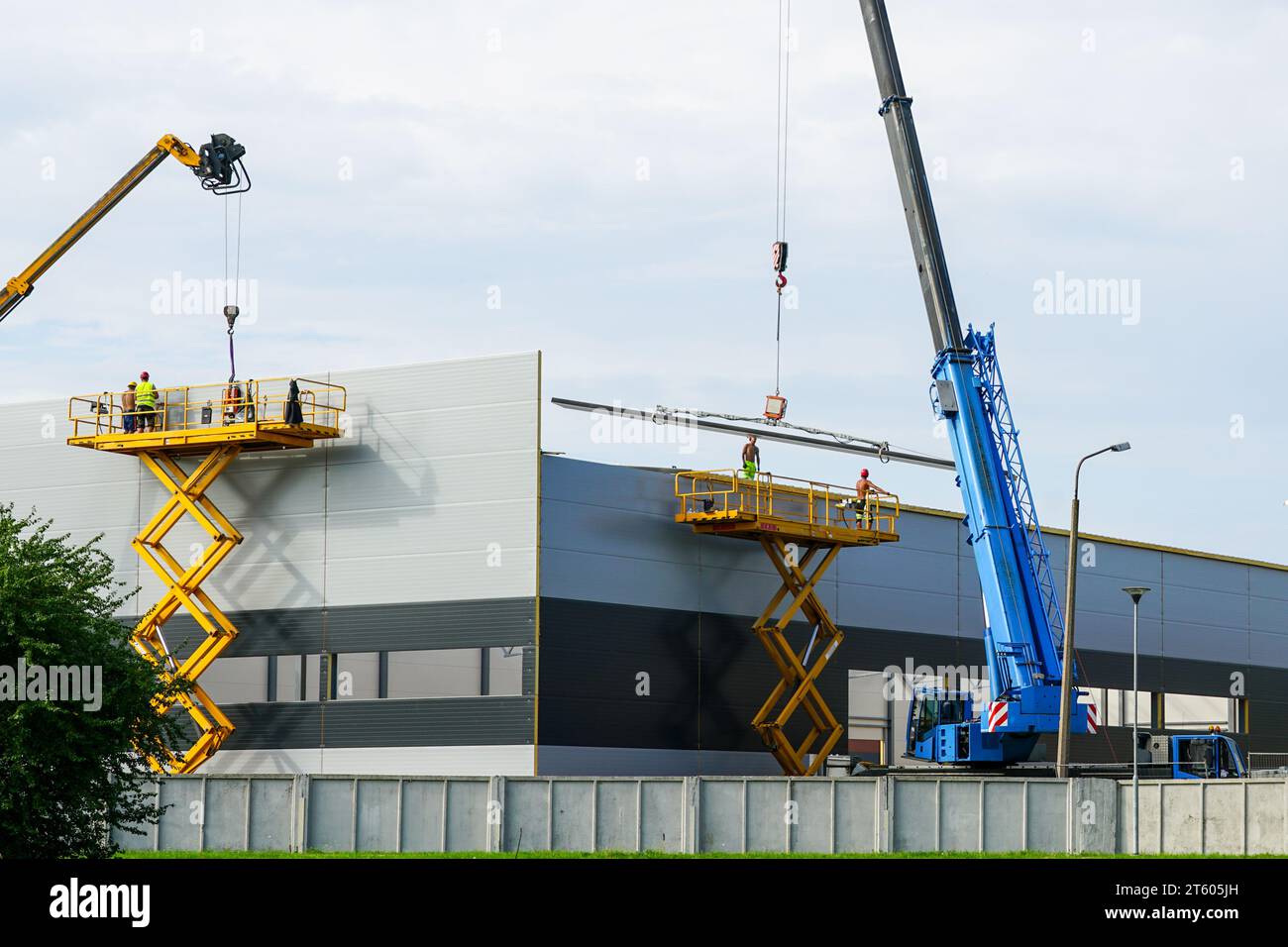 Assembly of sandwich panel walls and roof using two telescopic jib ...