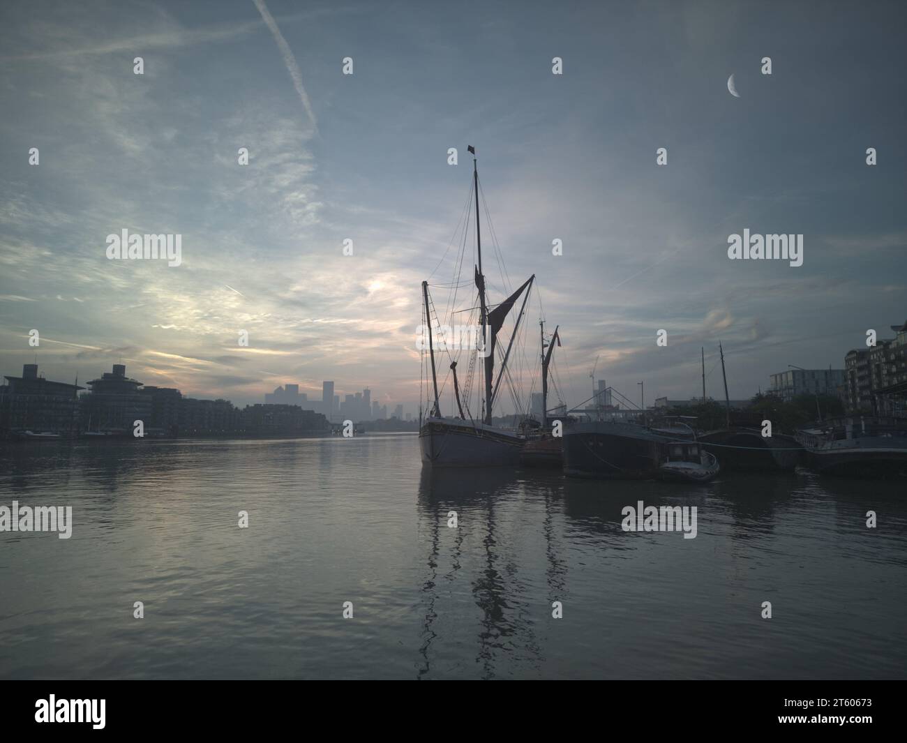 Pearly light of sunrise over River Thames (2). Sailing barge with ...