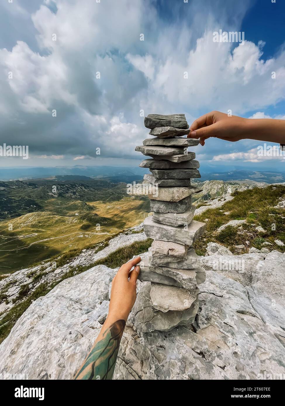 Hands Stacking Stones for Cairn Tower in Mountains Stock Photo - Alamy