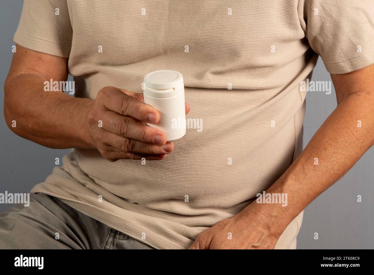 Hand holding bottle of pills representing different diseases. At home ...