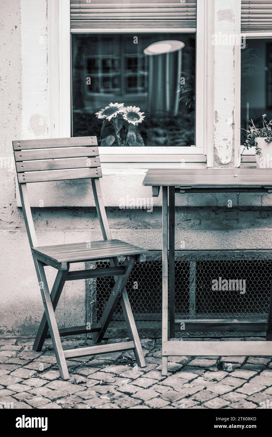 Vertical image of half table with chair, flowers and house facade Stock ...