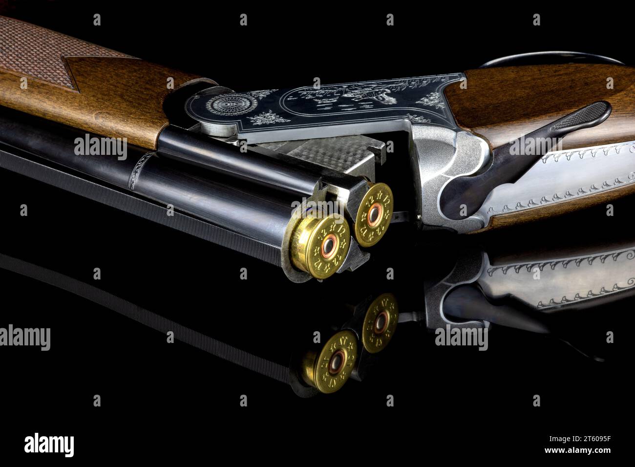 Over and under sporting shotgun loaded with cartridges on a reflective ...