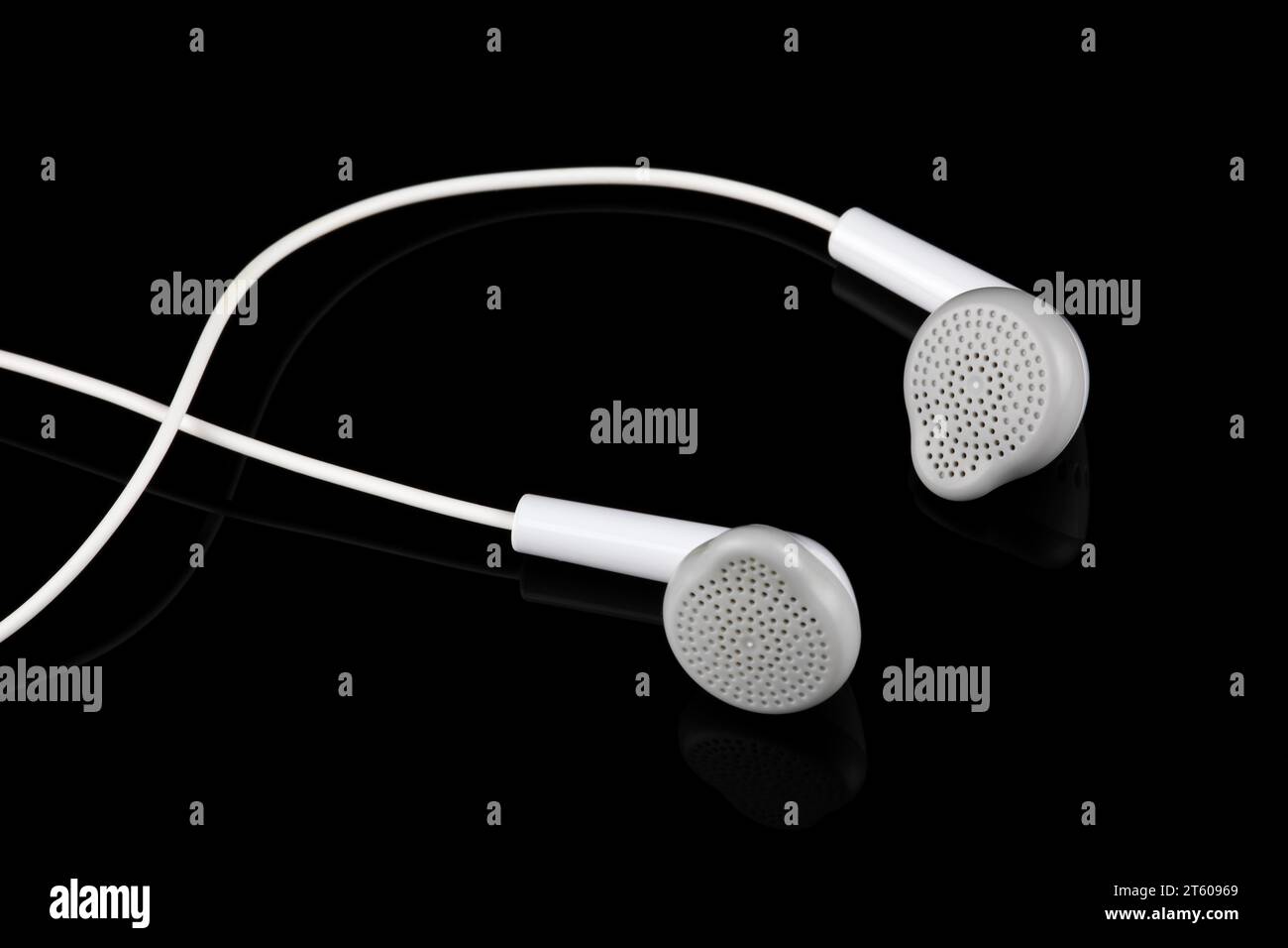 Wired white earbuds isolated on a black reflective surface Stock Photo ...