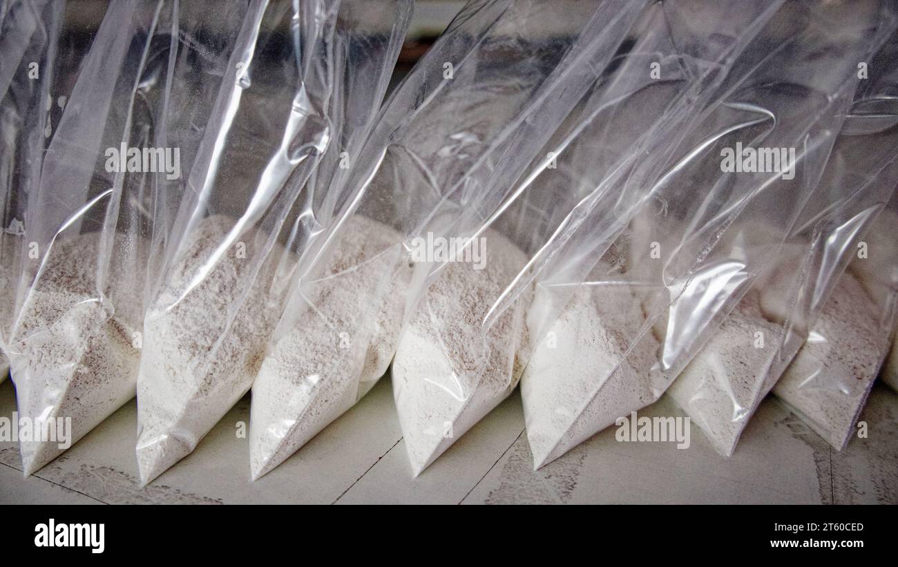 A large number of transparent sachets filled with white powder. White ...